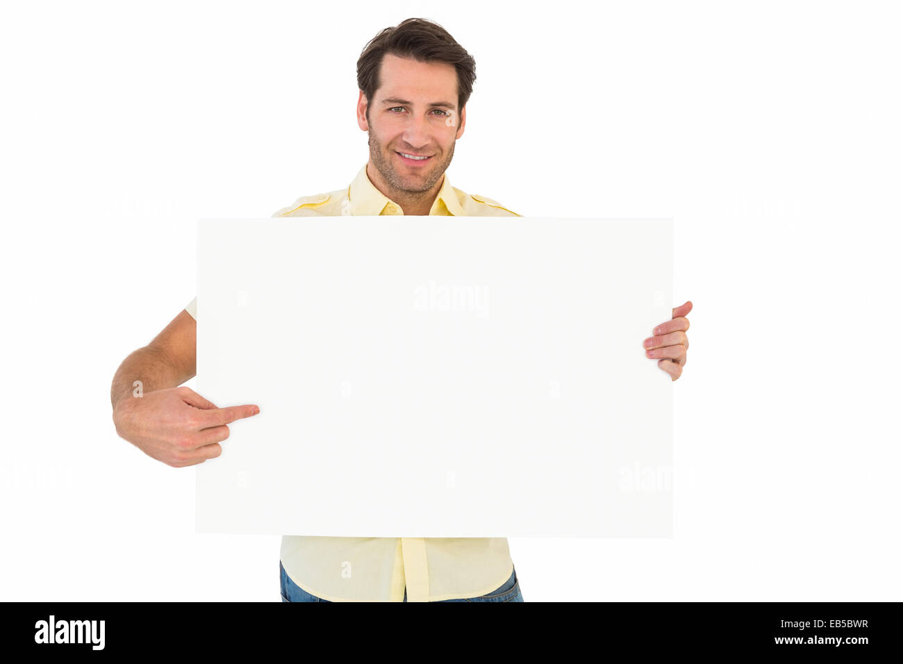 Handsome man smiling and pointing white poster Stock Photo - Alamy