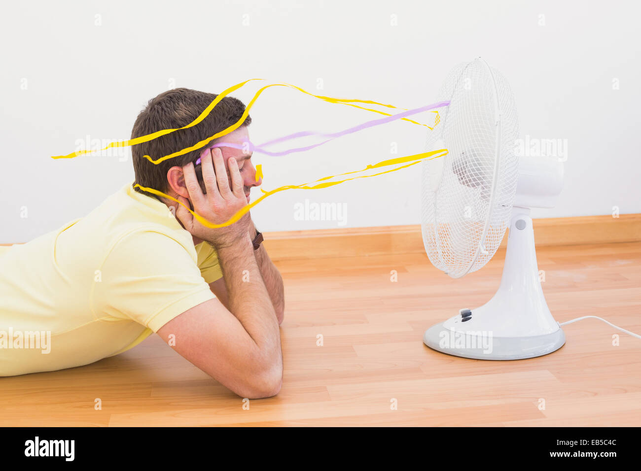 Man lying on floor looking at fan at home Stock Photo - Alamy