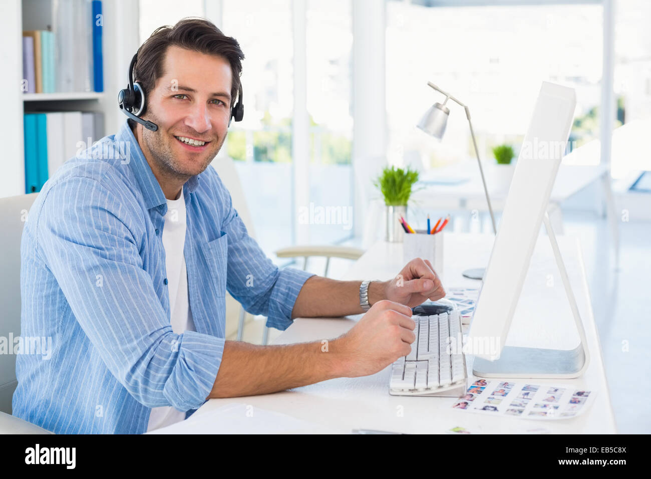 Smiling photo editors wearing a headphone Stock Photo - Alamy