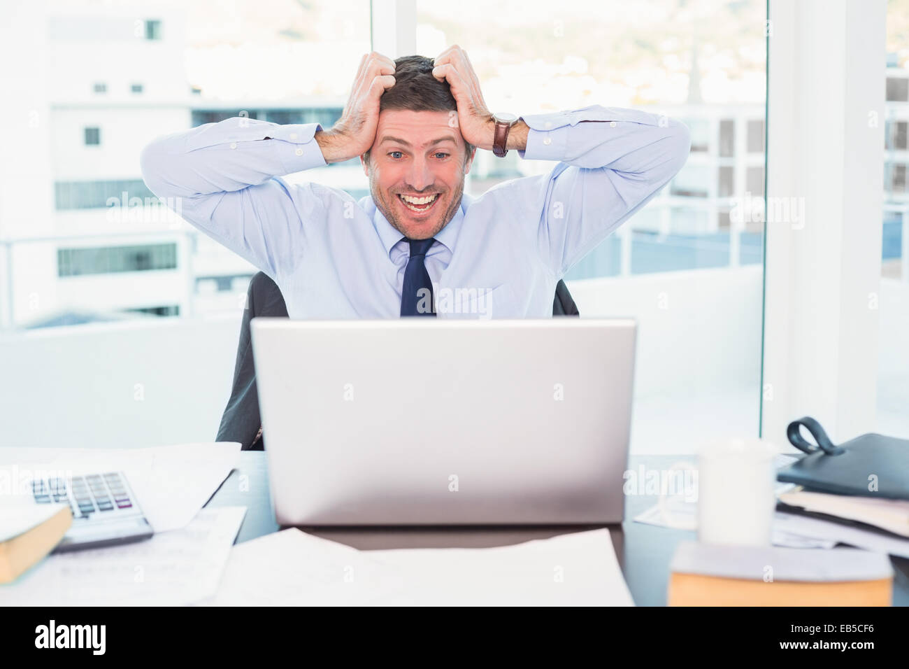 Smiling businessman taking his head Stock Photo - Alamy