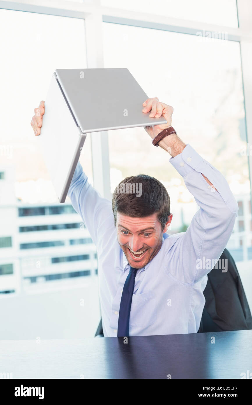 Angry businessman throwing his laptop Stock Photo - Alamy