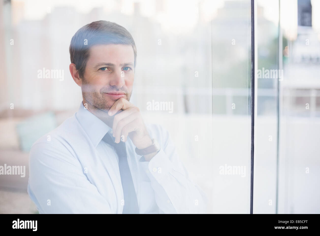 Smiling businessman looking out the window Stock Photo - Alamy