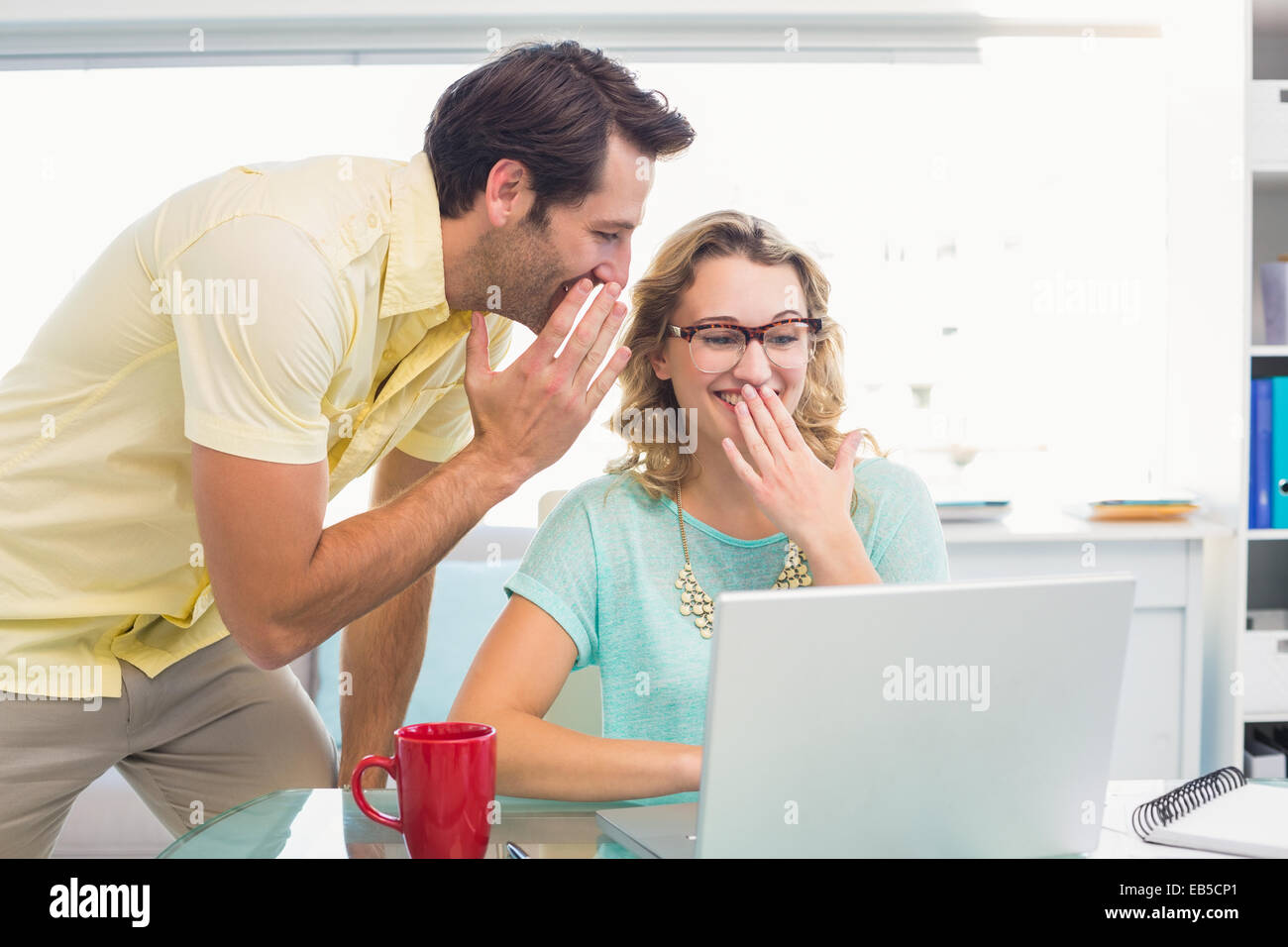 Cheerful creative business laughing while working Stock Photo - Alamy