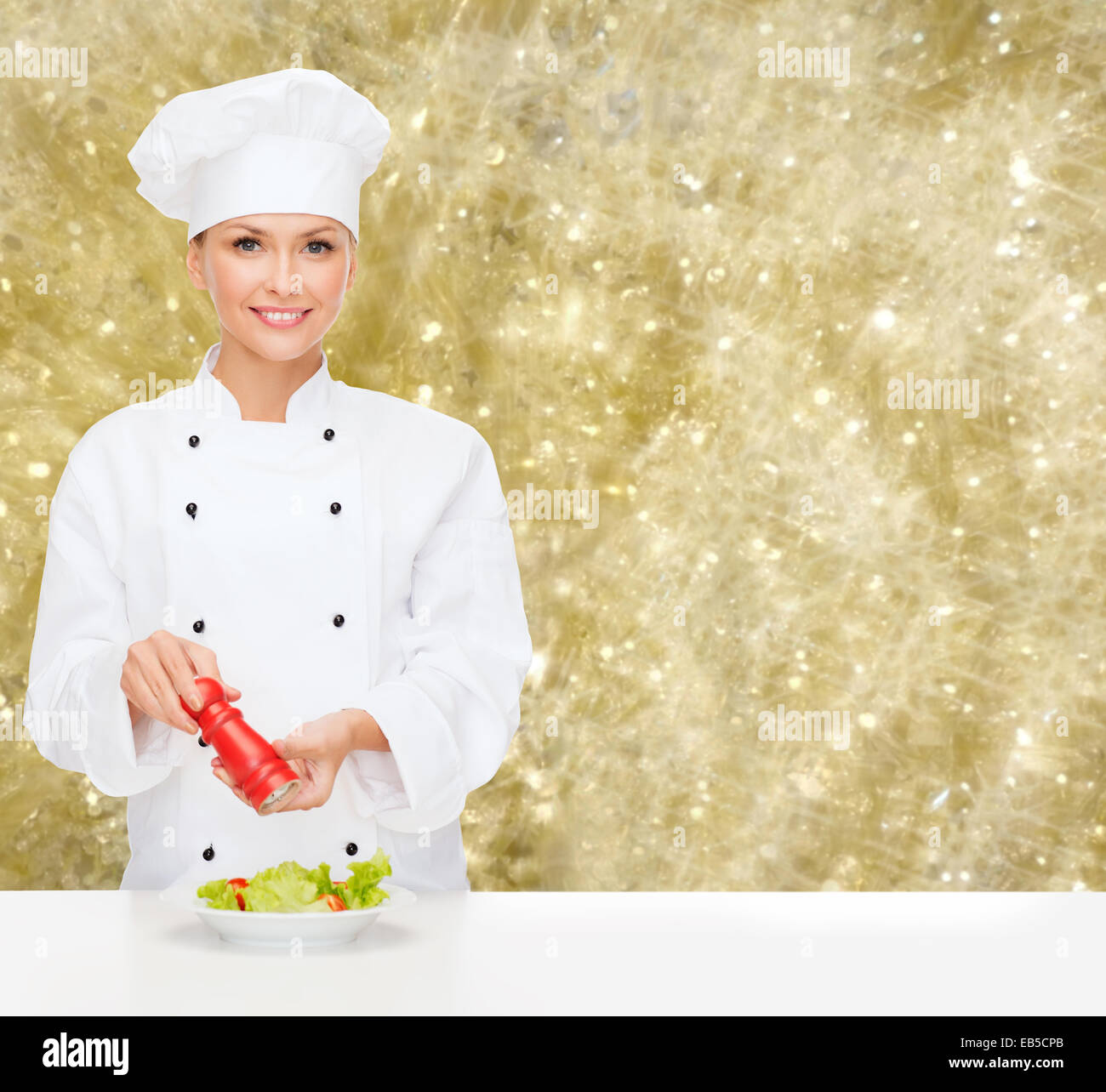 smiling female chef spicing vegetable salad Stock Photo - Alamy