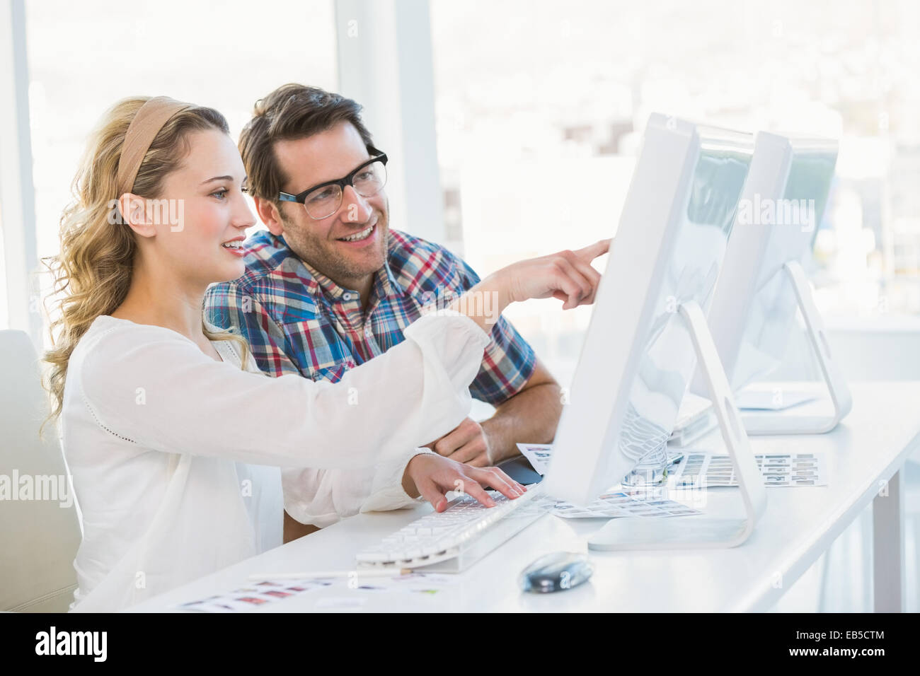 Smiling photo editors using computer Stock Photo - Alamy