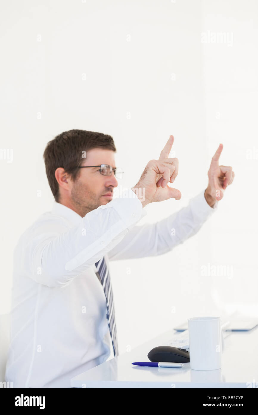 Businessman holding hands up at desk Stock Photo - Alamy