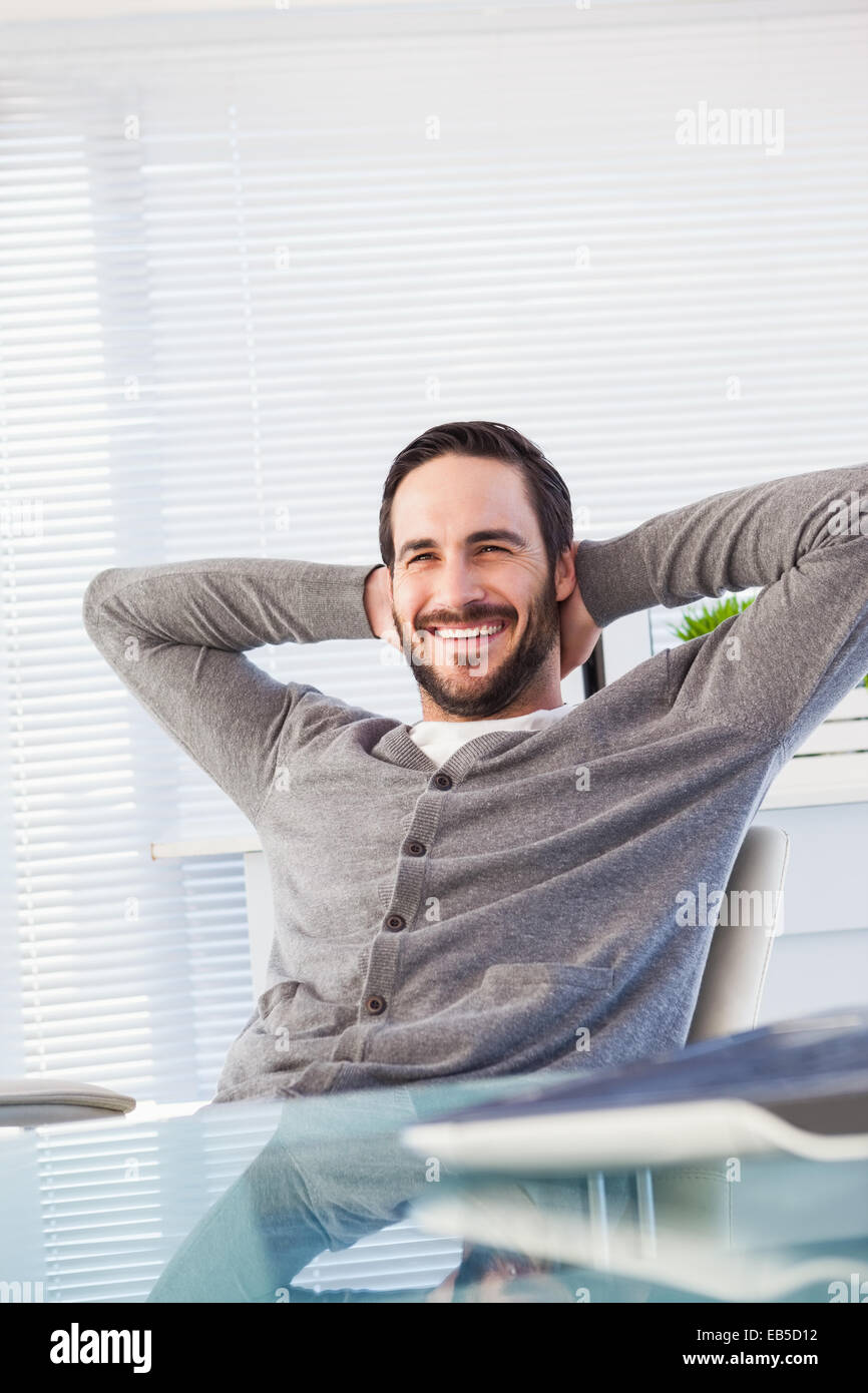 Relaxed casual businessman leaning back at his desk Stock Photo - Alamy