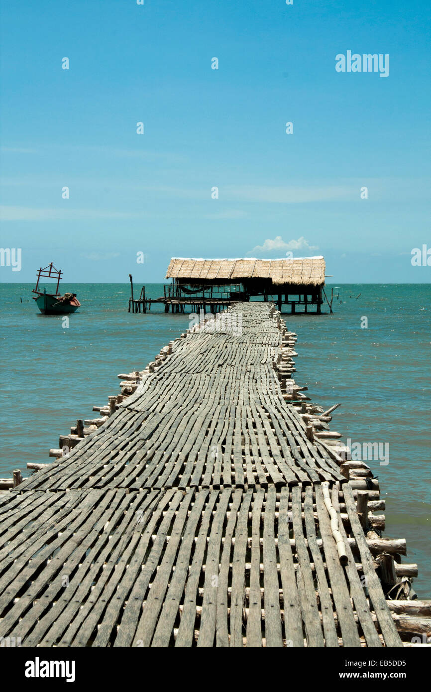 pier or jetty made from bamboo that leads to a covered hut with one ...