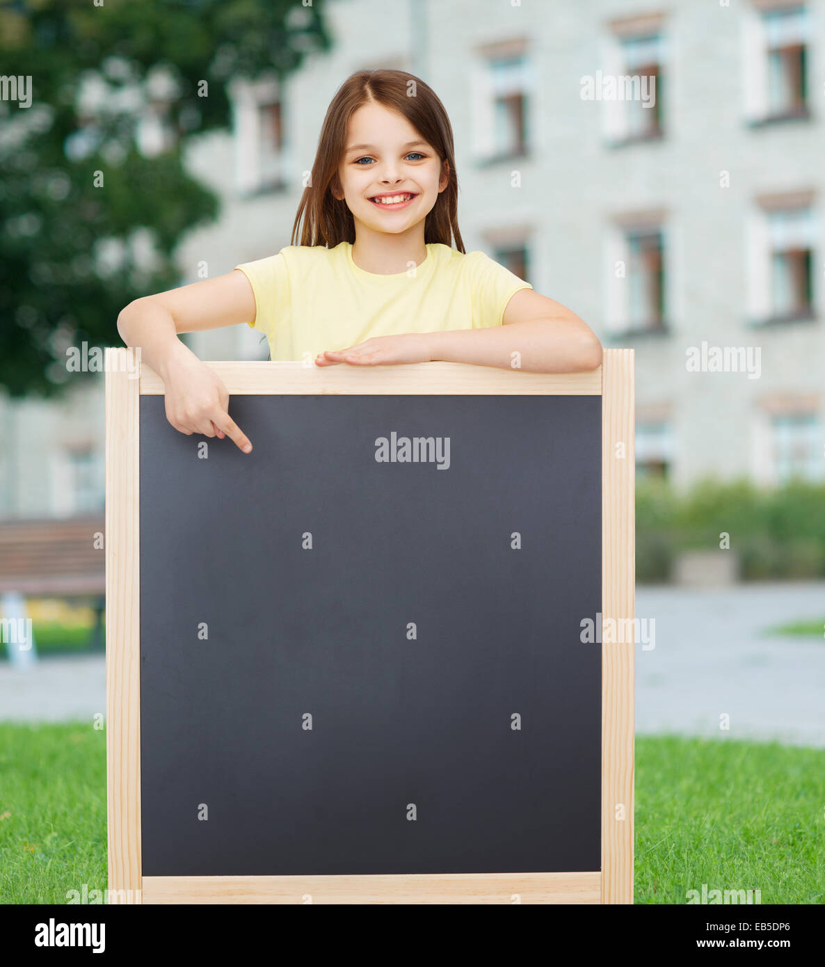 happy little girl pointing finger to blackboard Stock Photo - Alamy