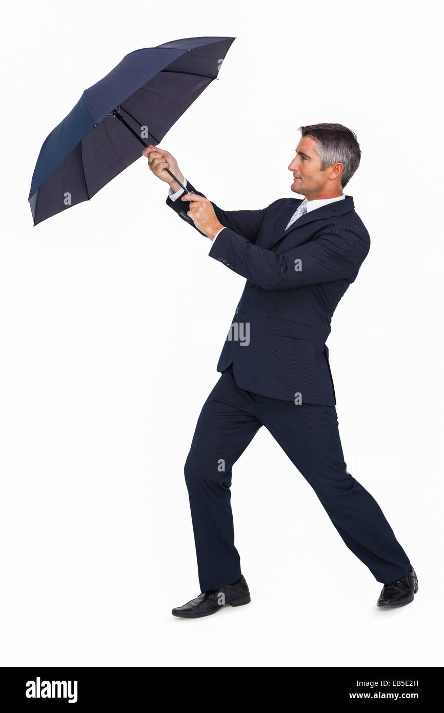 Businessman pushing the wind with umbrella Stock Photo - Alamy