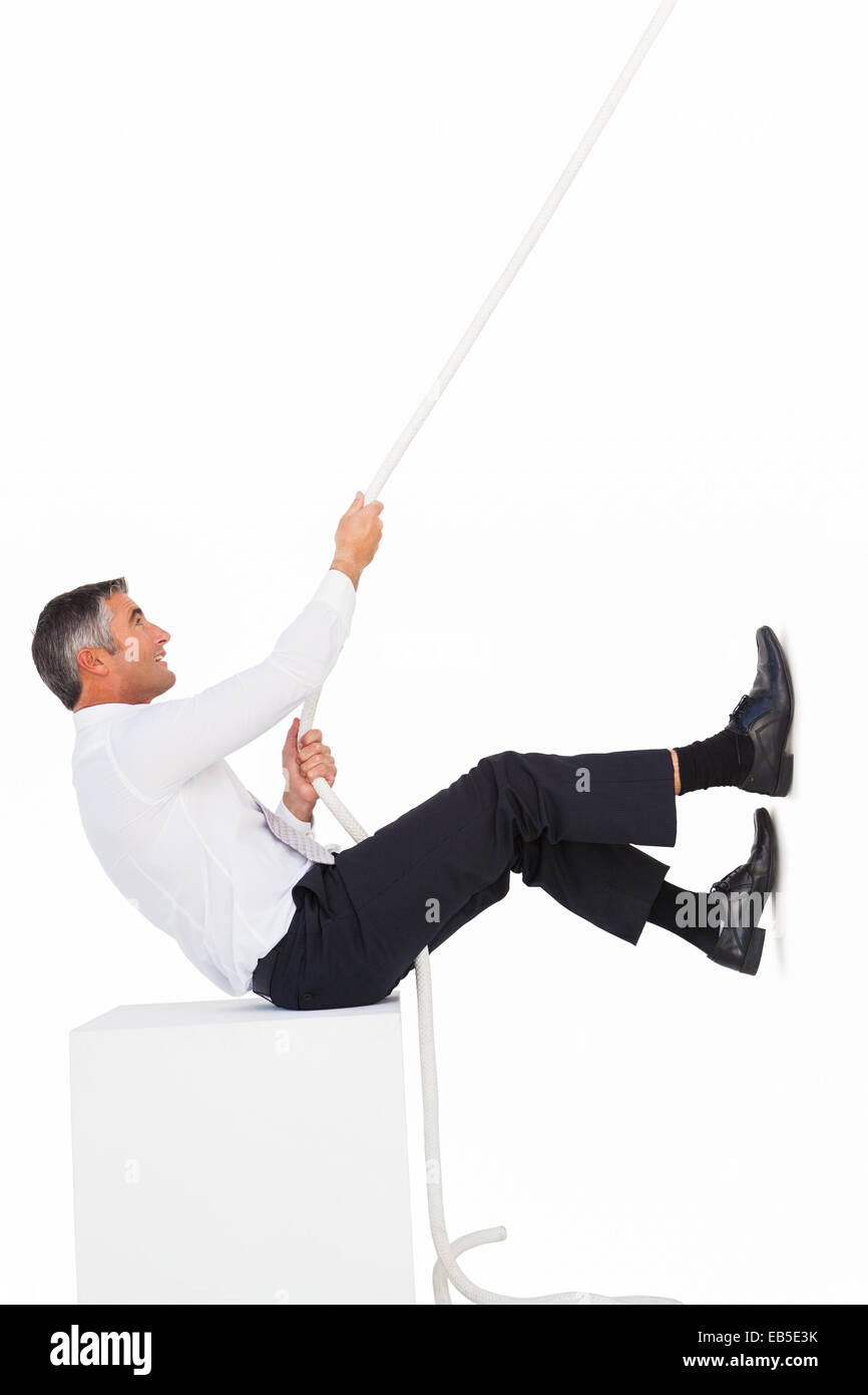 Businessman sitting and pulling a rope Stock Photo - Alamy
