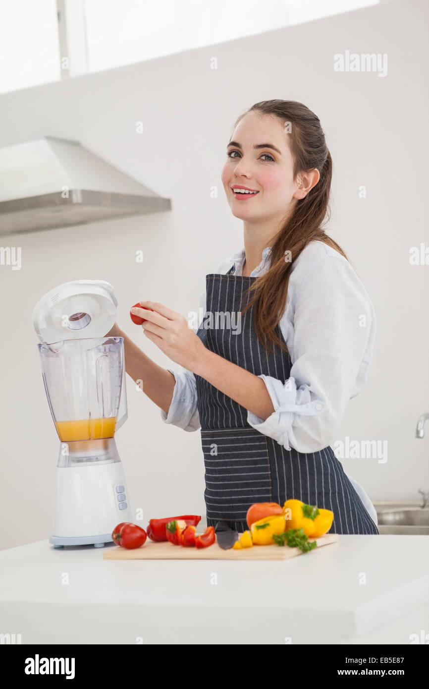 Pretty brunette making a healthy juice Stock Photo - Alamy