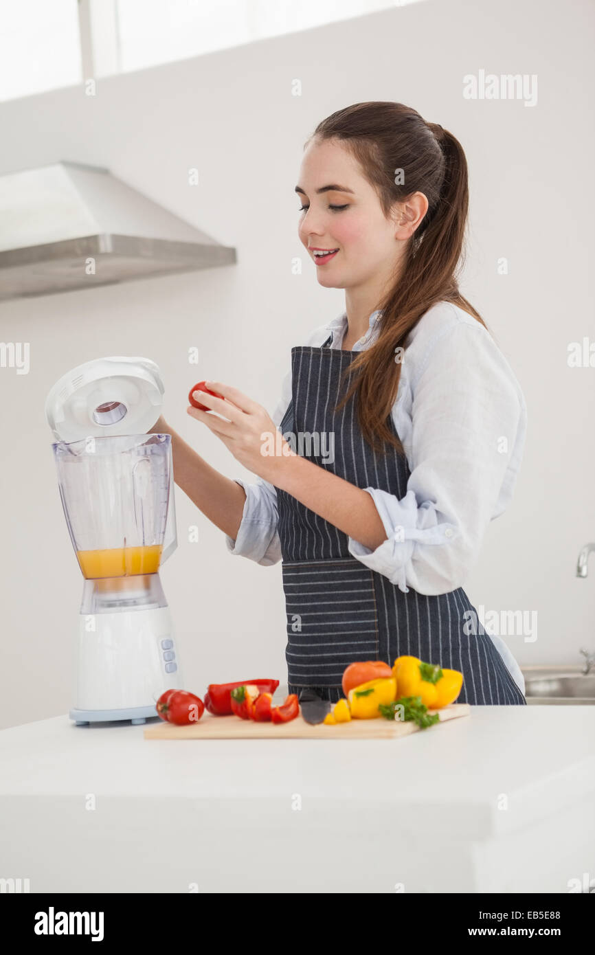 Pretty brunette making a healthy juice Stock Photo - Alamy