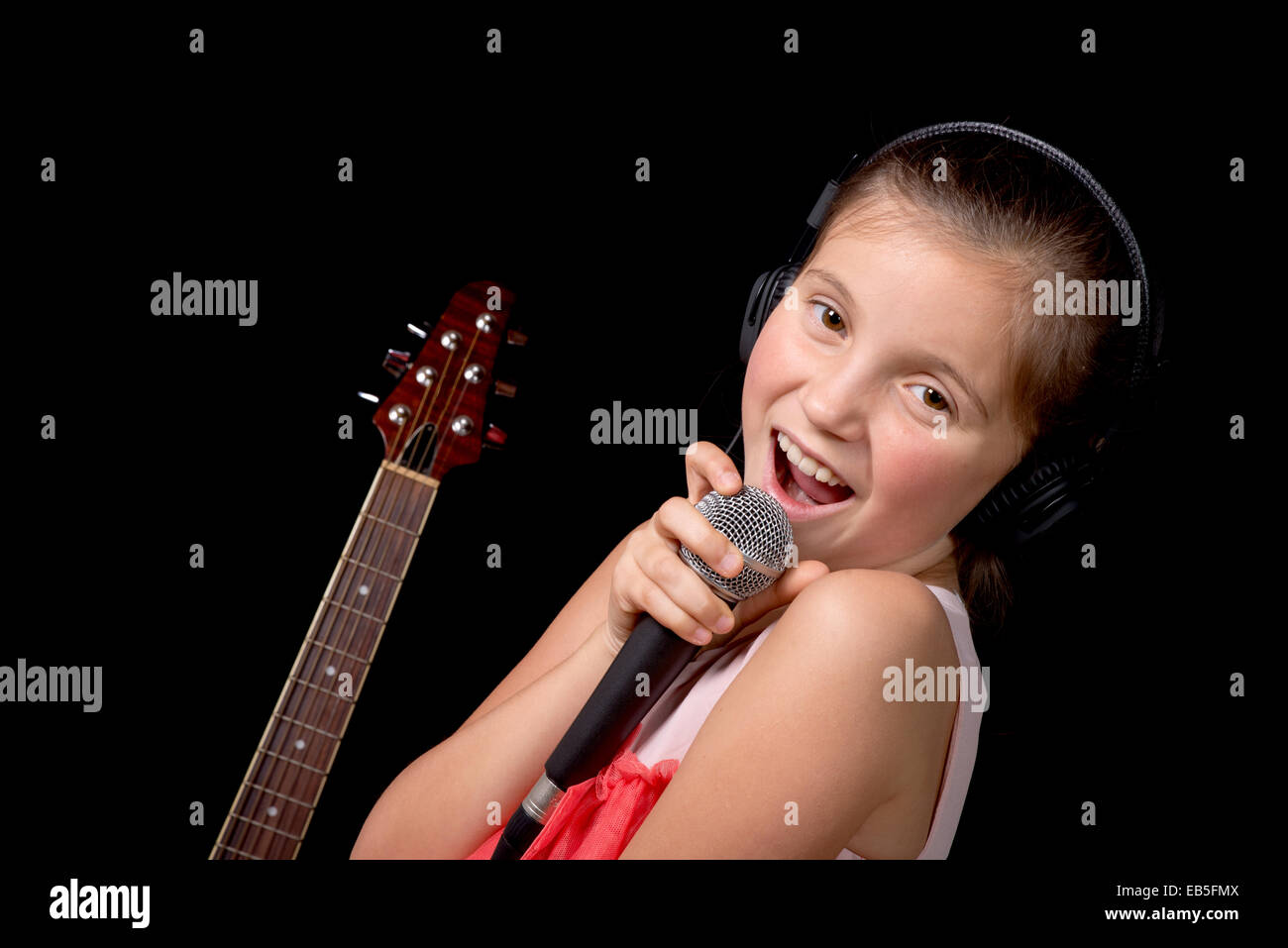 a young girl with headphones singing with a microphone Stock Photo - Alamy