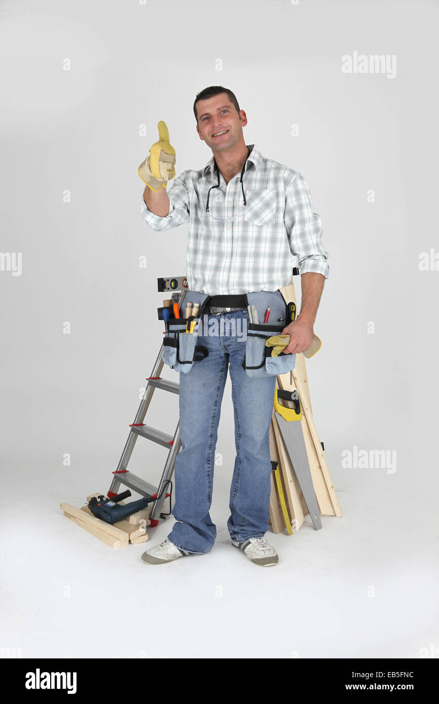Carpenter standing by ladder giving the thumbs up Stock Photo - Alamy