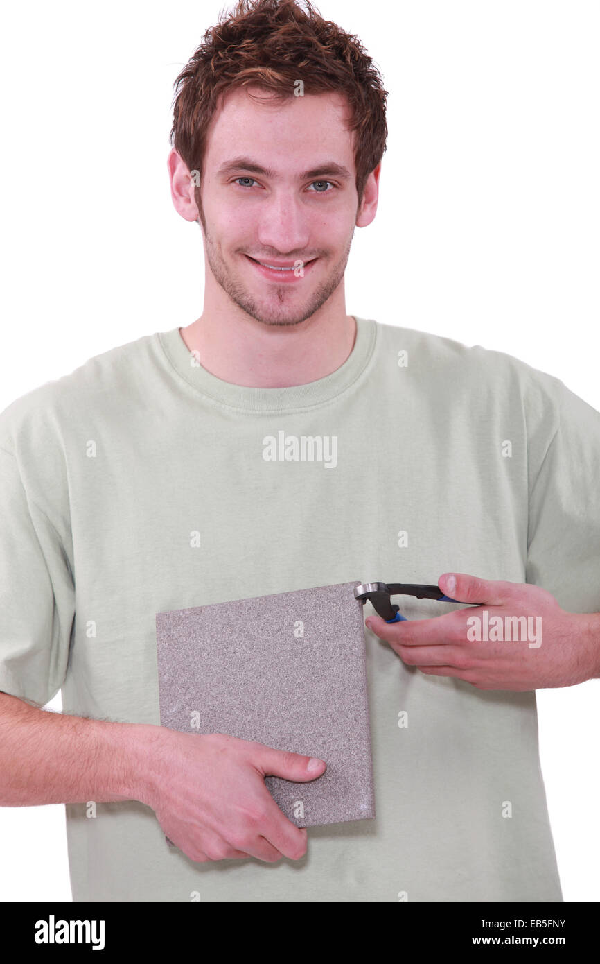 young man holding a tile and a nipper Stock Photo - Alamy