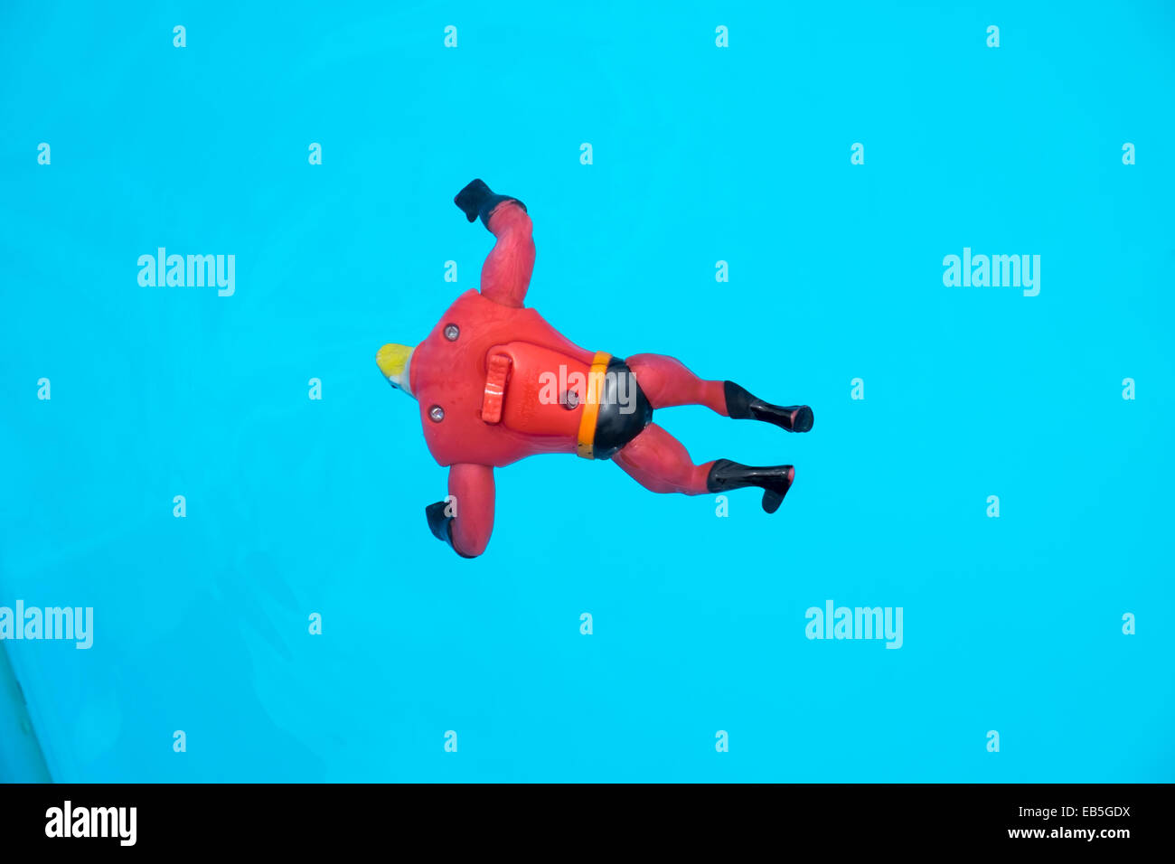 Red toy super hero floating in a blue swimming pool Stock Photo - Alamy