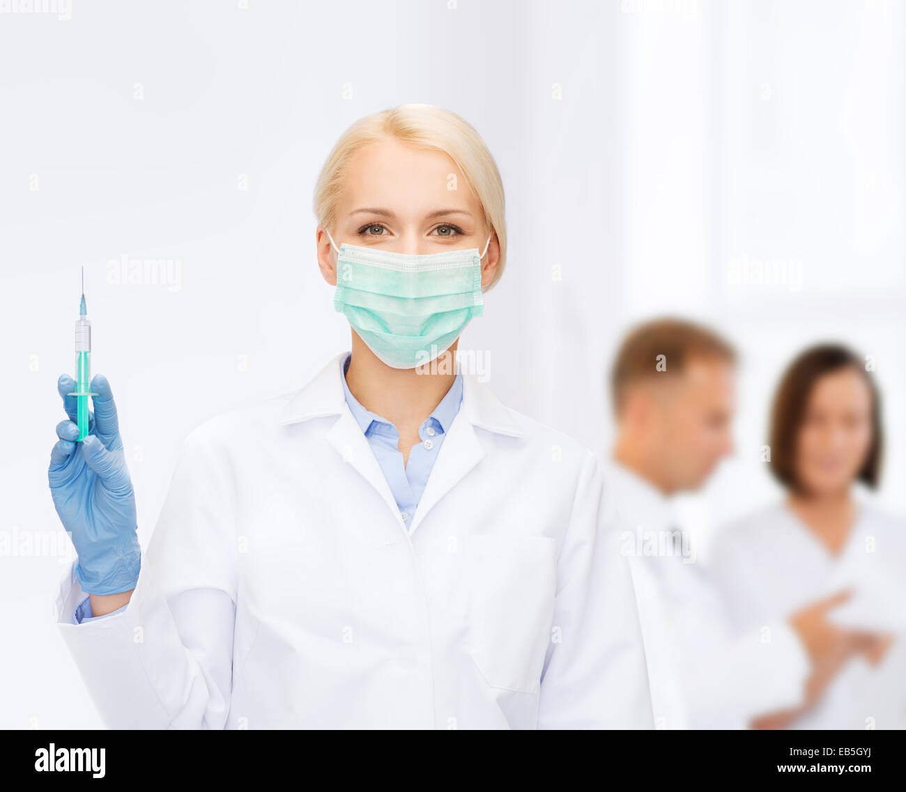 doctor in mask holding syringe with injection Stock Photo - Alamy