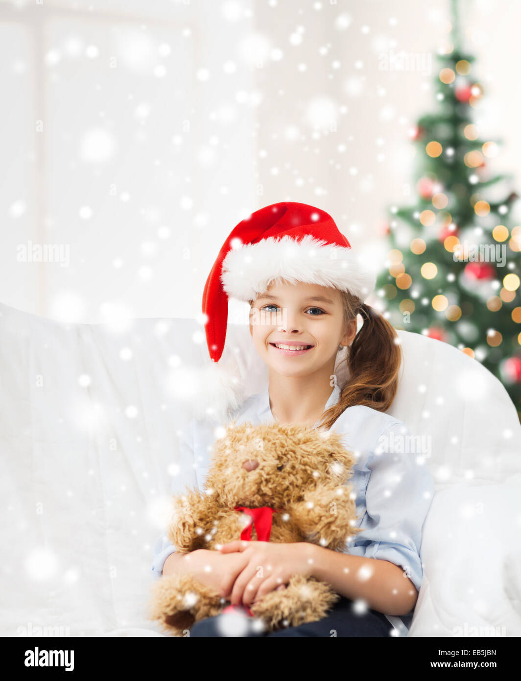 smiling girl in santa helper hat with teddy bear Stock Photo - Alamy