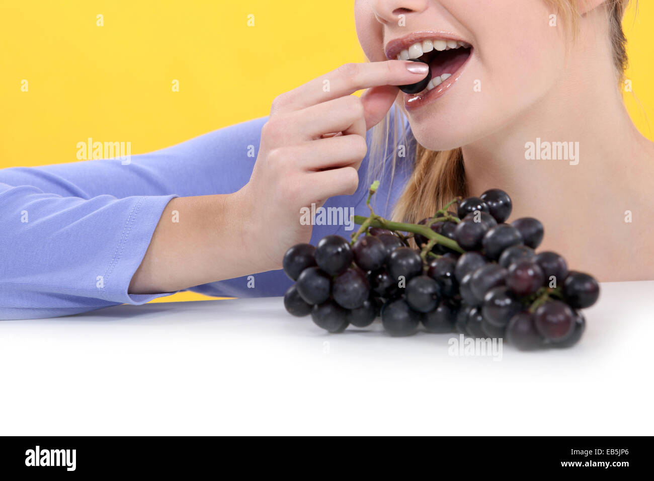 Woman eating grapes Stock Photo - Alamy