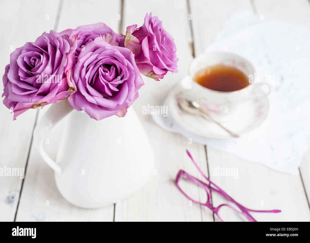 Tea break - pink roses in white jug on white table, vintage teacup and ...