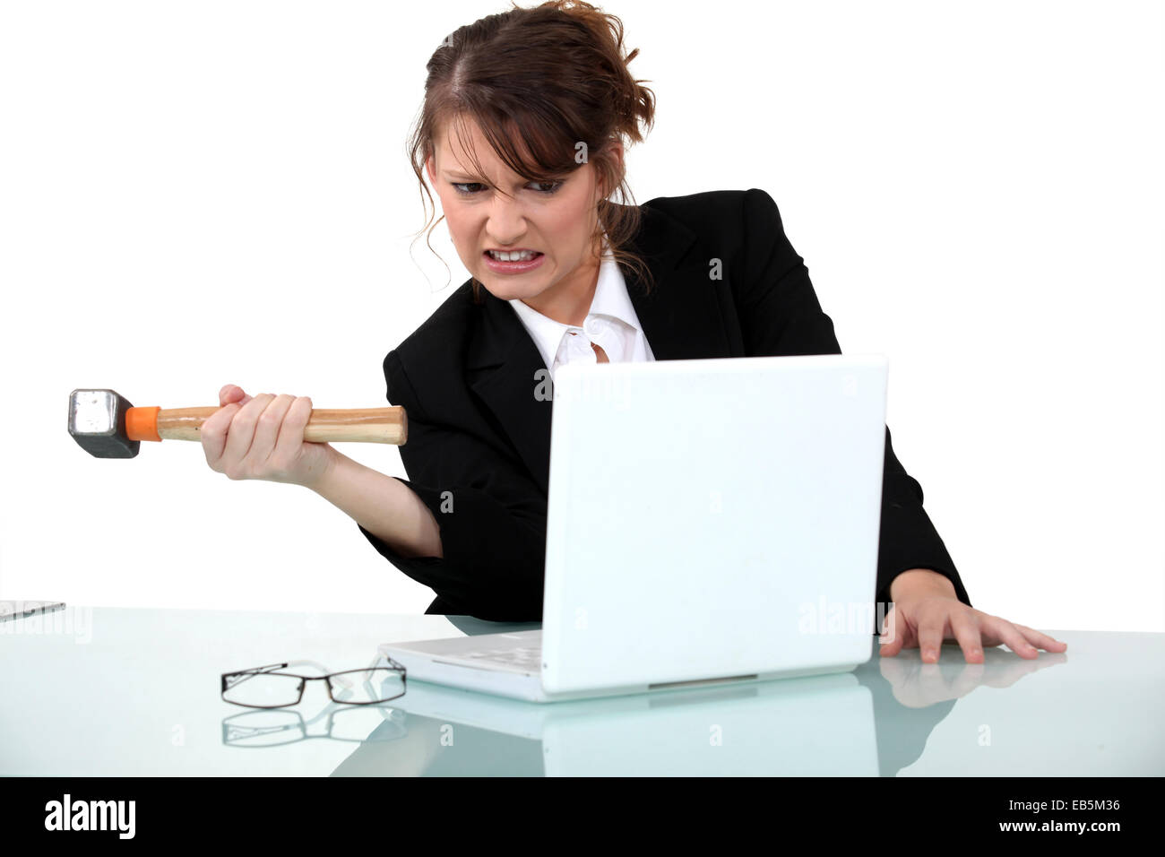 Woman threatening computer with hammer Stock Photo - Alamy