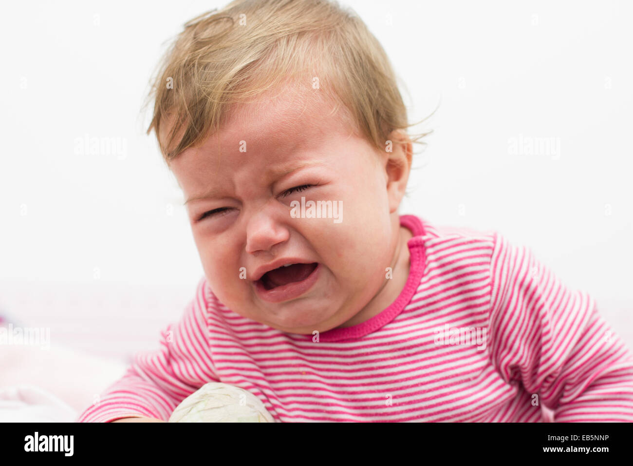 Unhappy crying baby girl nine-month looking at the camera Stock Photo ...