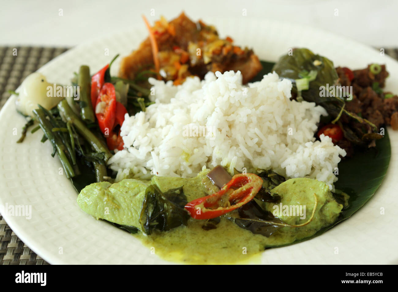 Steamed rice served with fresh vegetables, chicken curry and beef ...