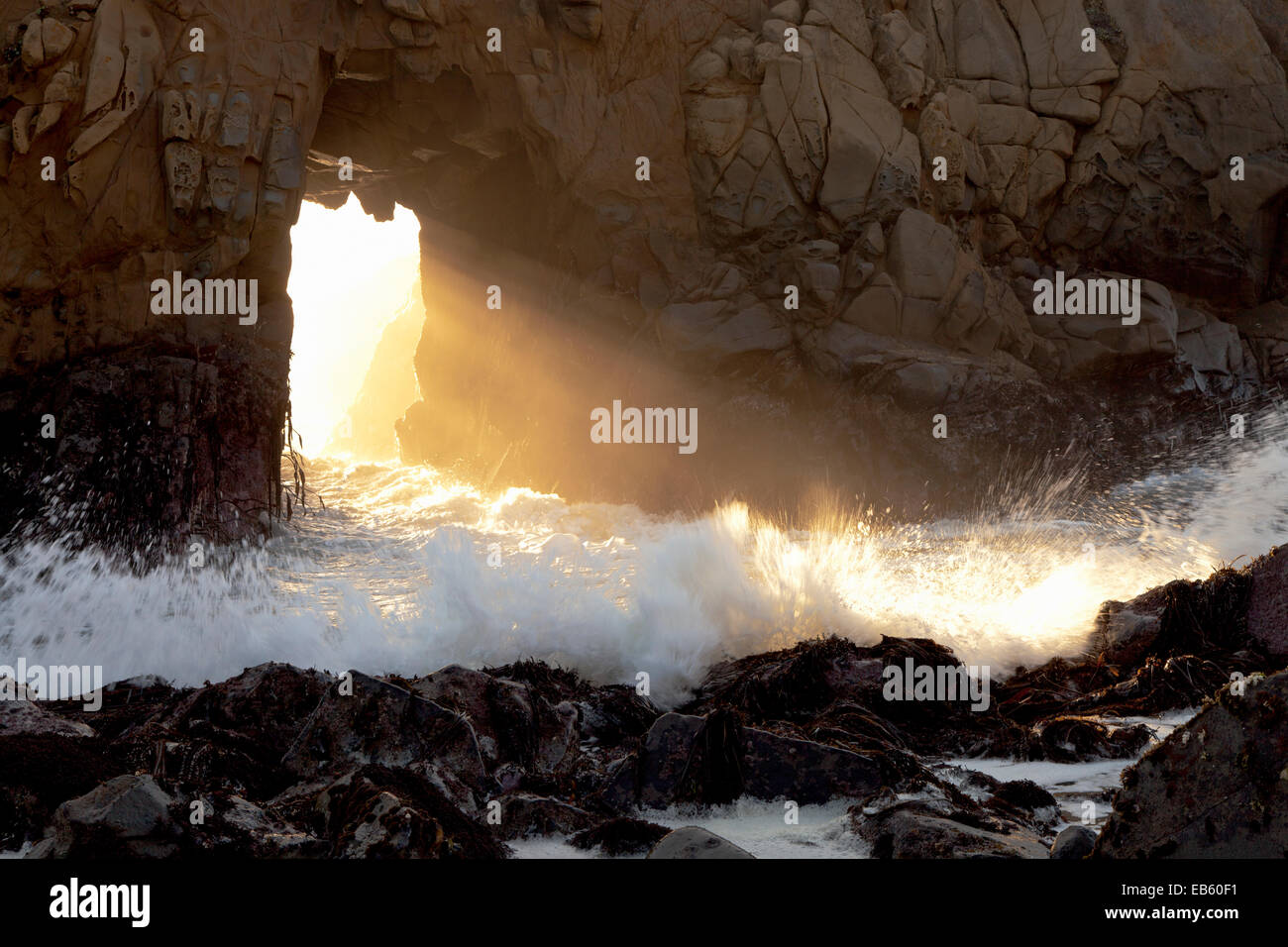 Sunlight and surf stream through Keyhole Arch at Pfeiffer Beach along ...