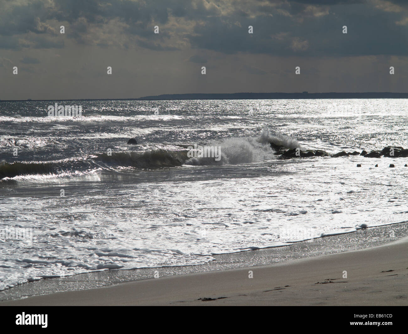 Atlantic ocean shore line with light blue sky sun breaking threw clouds ...