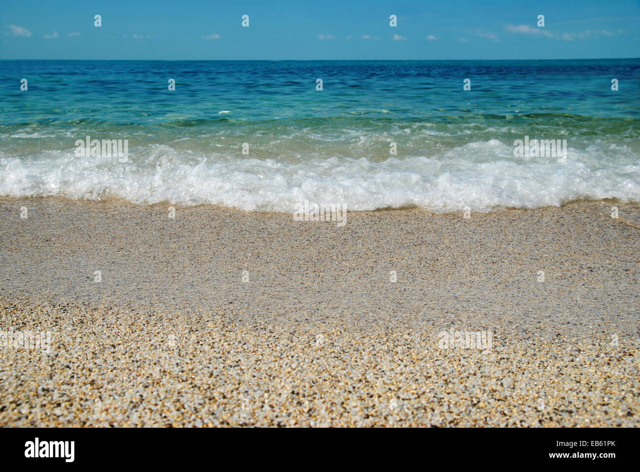 Tropical sand beach with sea waves and stones Stock Photo - Alamy
