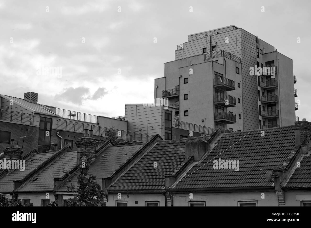 Tower block set against terraced rooftops in black and white Stock ...