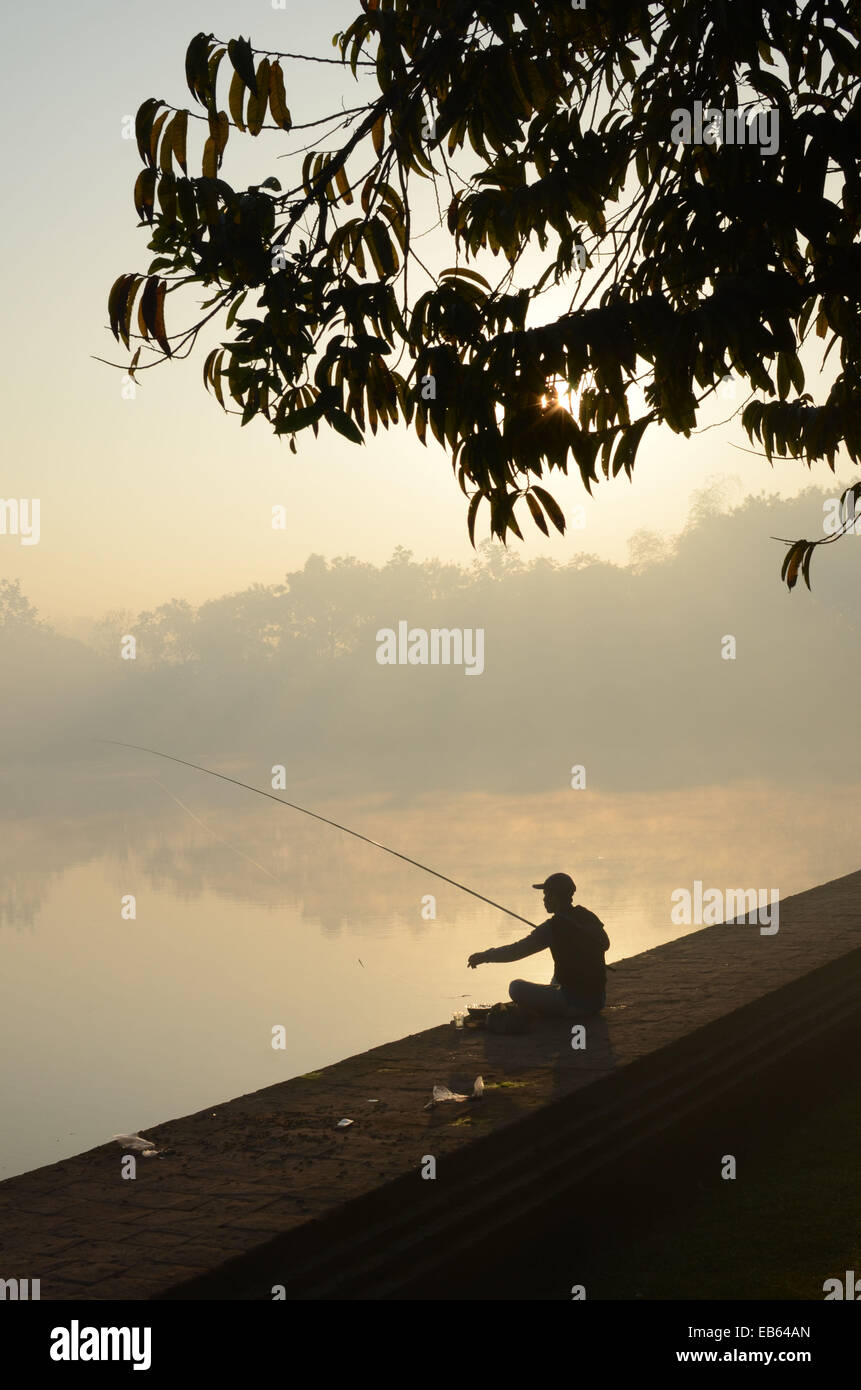 A resident fishing at Segaran pool in the village of Trowulan. An area ...