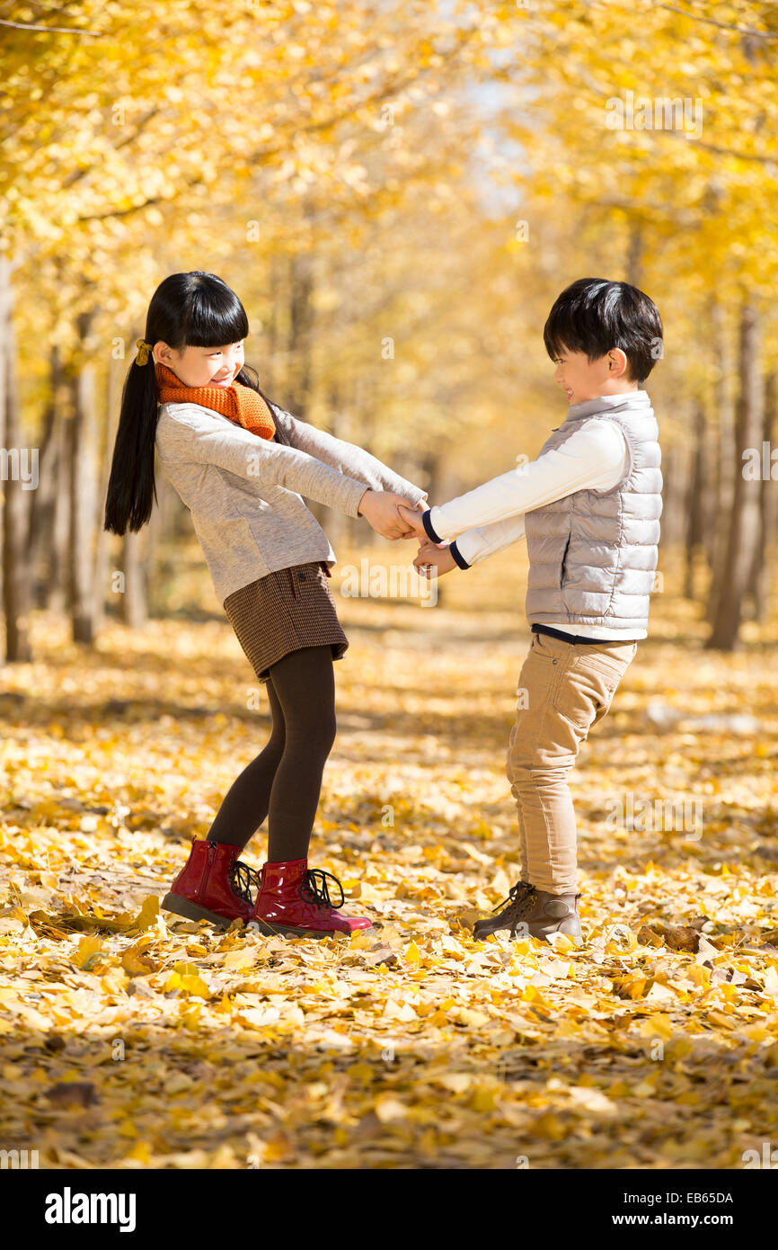 Two children playing in autumn woods Stock Photo - Alamy