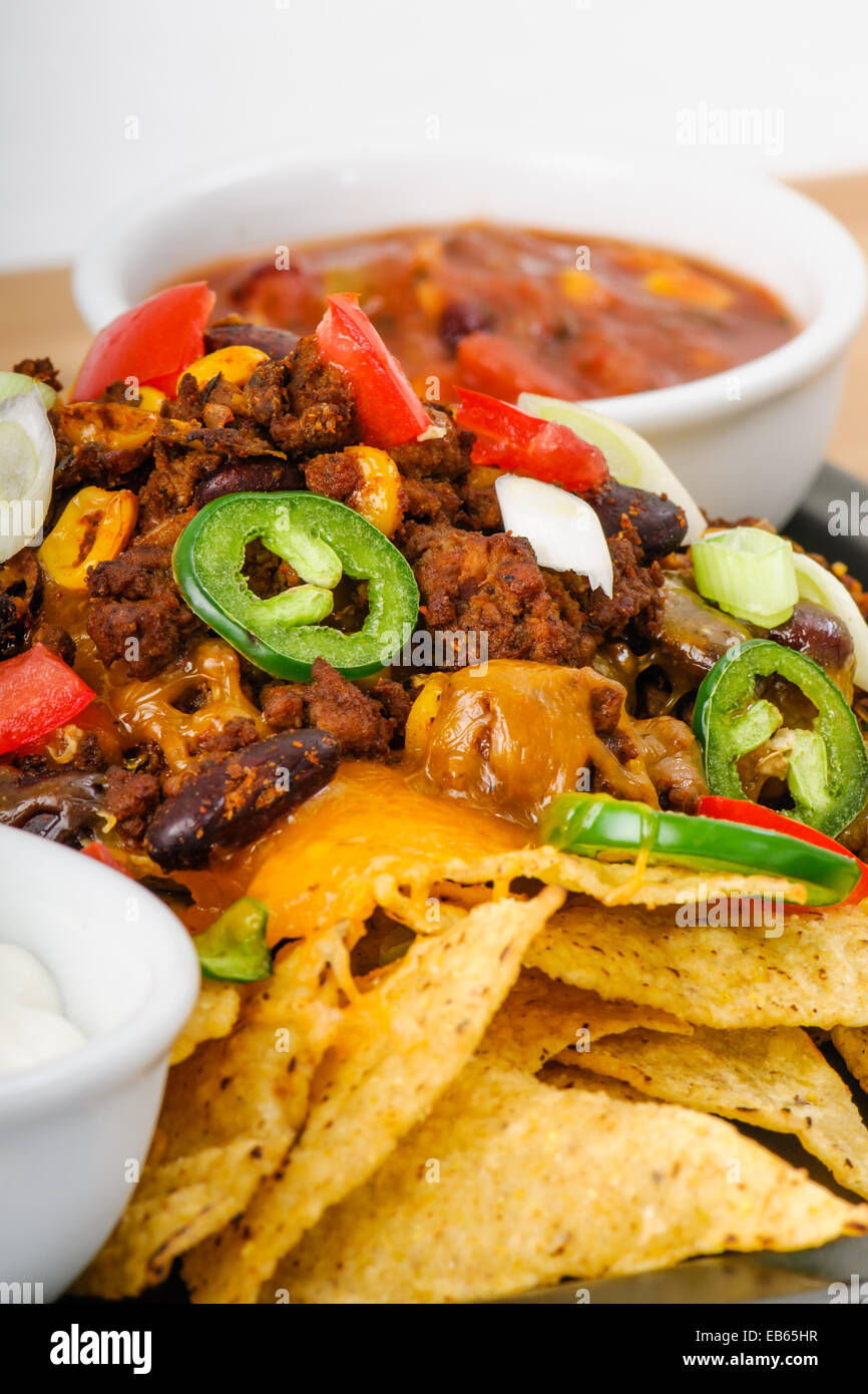 Chili and Cheddar Cheese Nacho platter with fresh Tomatoes, Onions ...