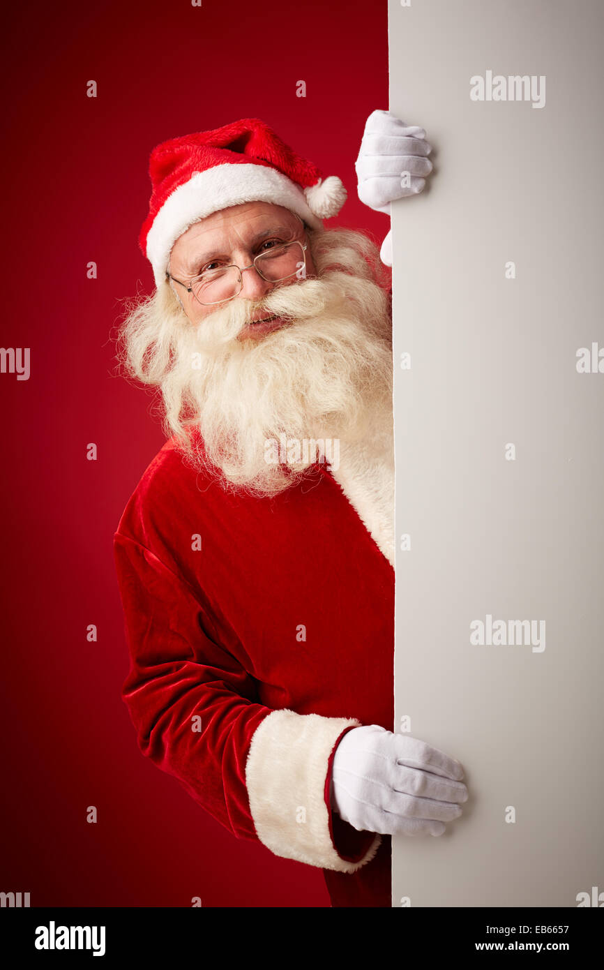 Happy Santa Claus looking at camera out of billboard Stock Photo - Alamy