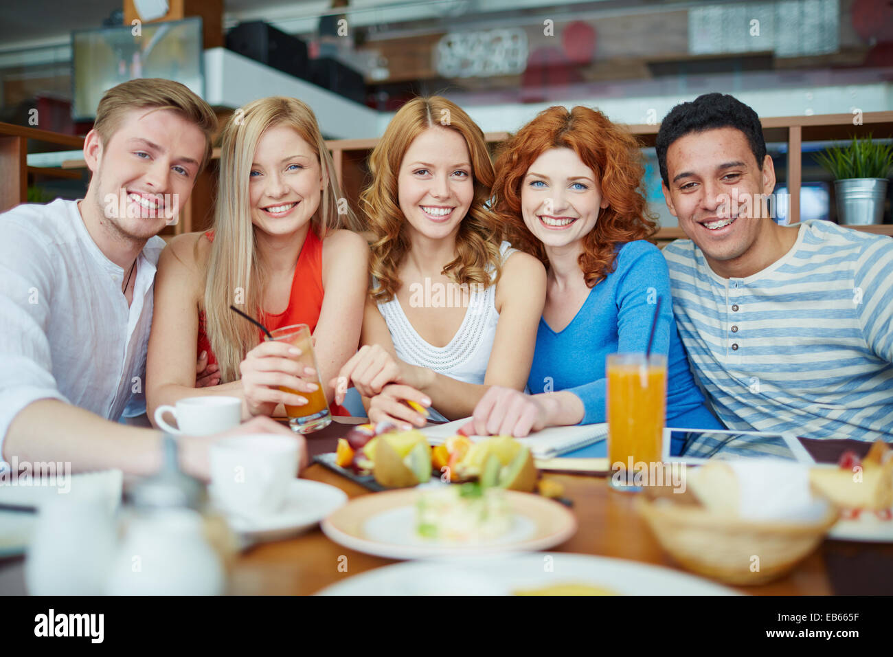 Group of happy friends sitting at cafe Stock Photo - Alamy