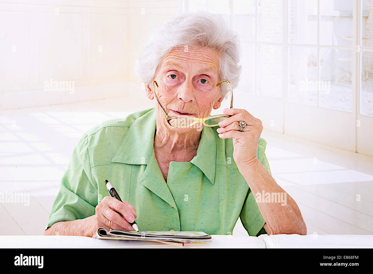 ELDERLY PERSON DOING CR-WORD PUZZLE Stock Photo - Alamy