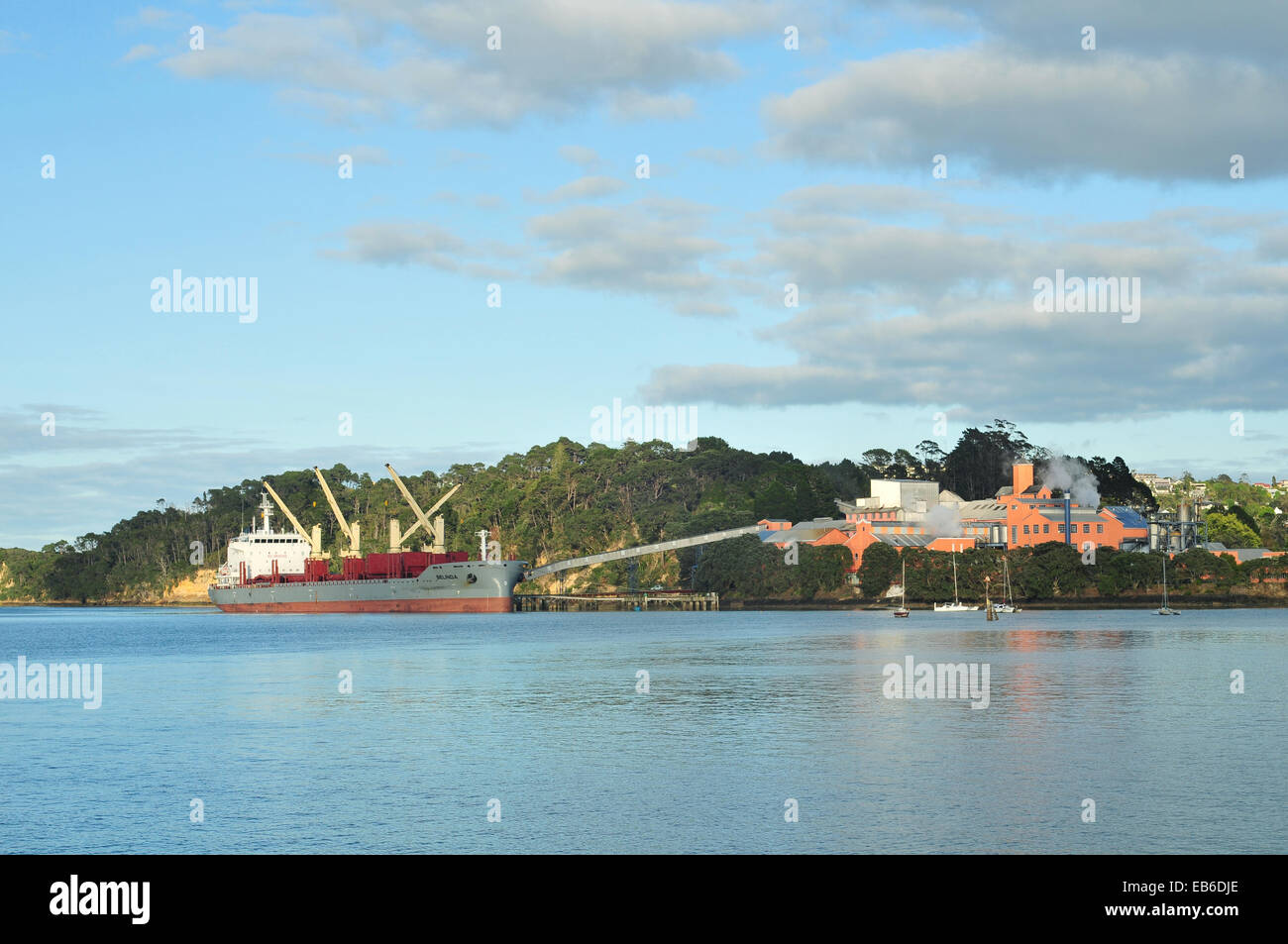 Cargo ship on calm surface of Waitemata Harbour at loading wharf of ...