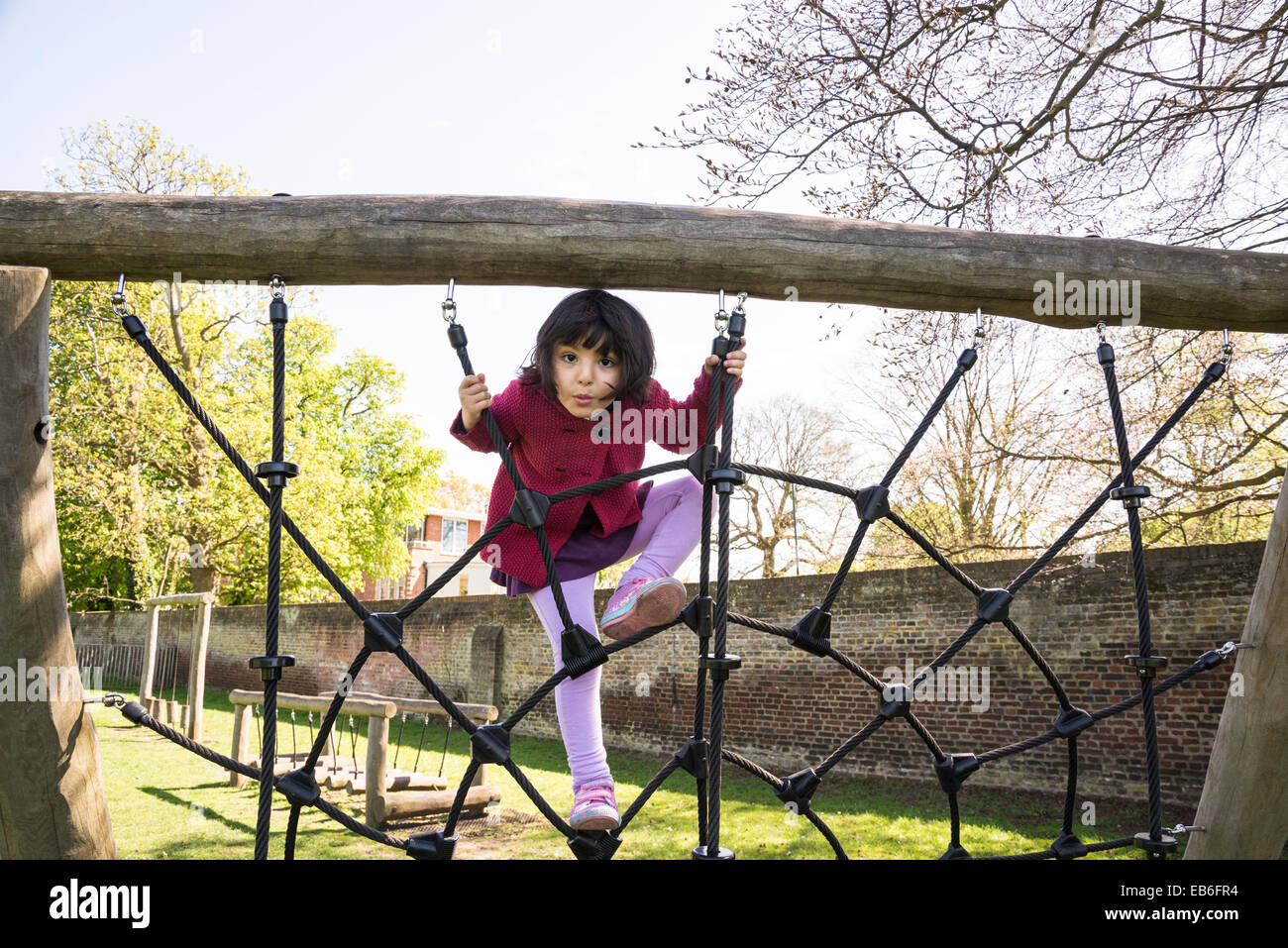 Five year old girl climbing spider's web in children's playground Stock ...