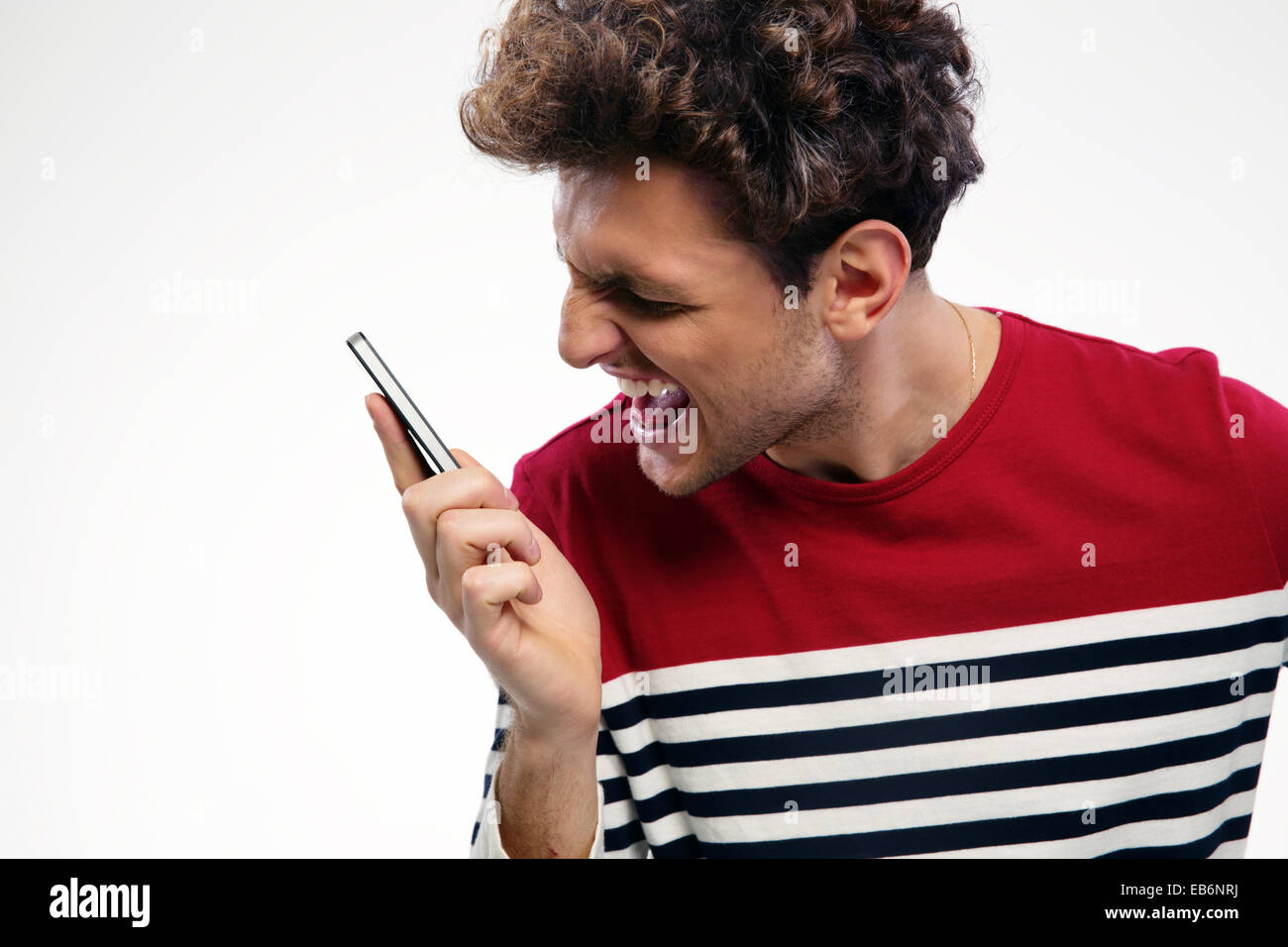 Angry man shouting at smartphone over gray background Stock Photo - Alamy
