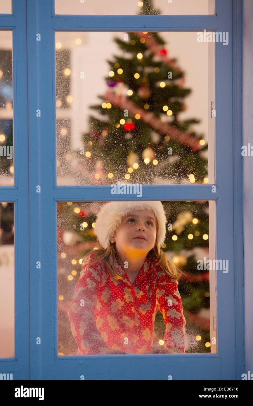 Young girl looking out of the window waiting for Santa to arrive Stock ...