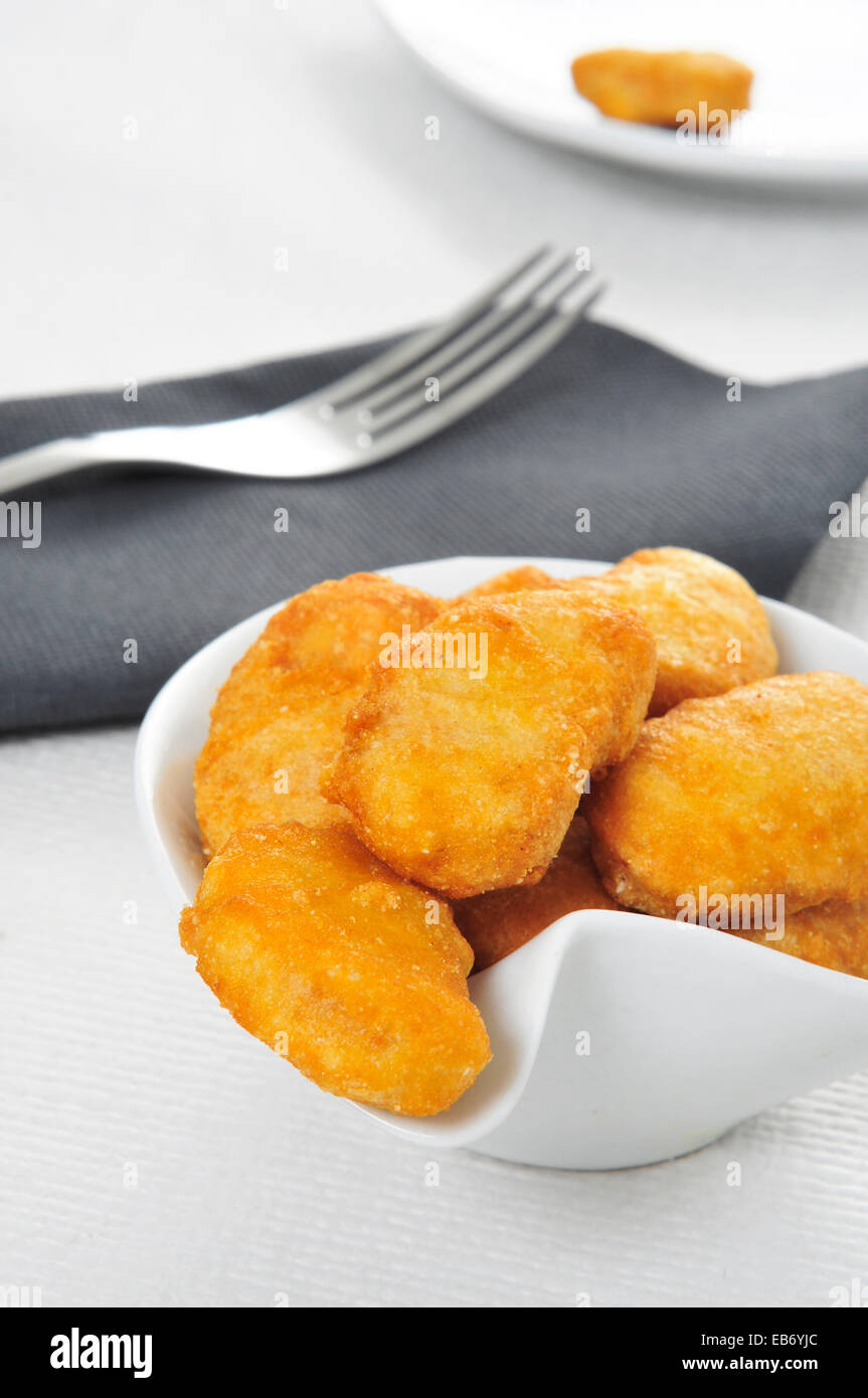 a bowl with chicken nuggets on a set table Stock Photo - Alamy