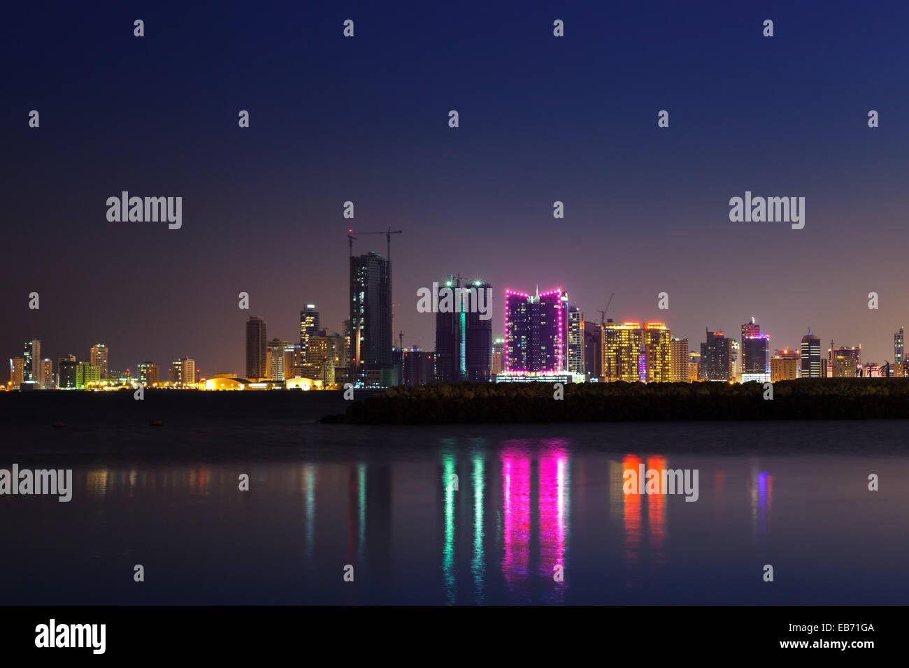 Night modern city skyline with shining lights and reflections in the ...