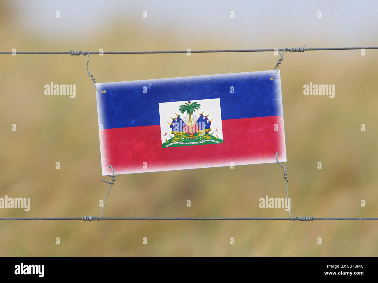 Border fence - Old plastic sign with a flag - Haiti Stock Photo - Alamy