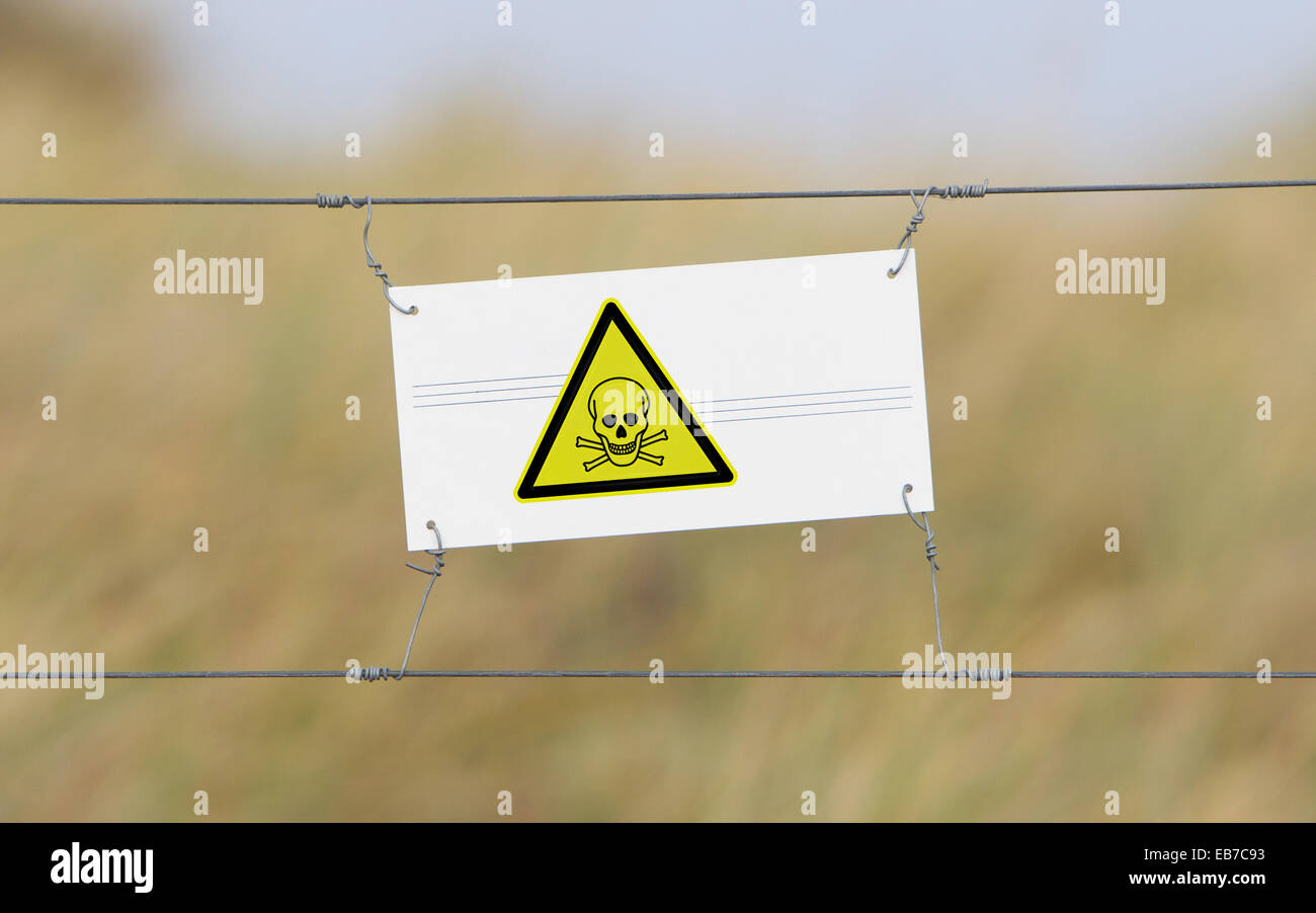 Border fence - Old plastic sign with a flag - Poison Stock Photo - Alamy