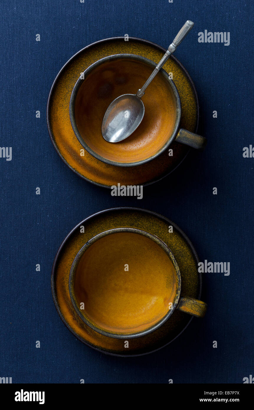 Two empty cups over dark blue cloth, above view Stock Photo - Alamy