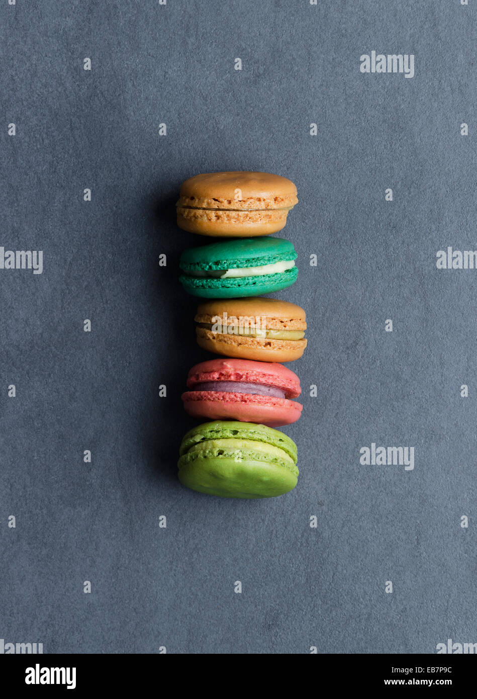 Macaroons biscuits in a row over dark blue table Stock Photo - Alamy