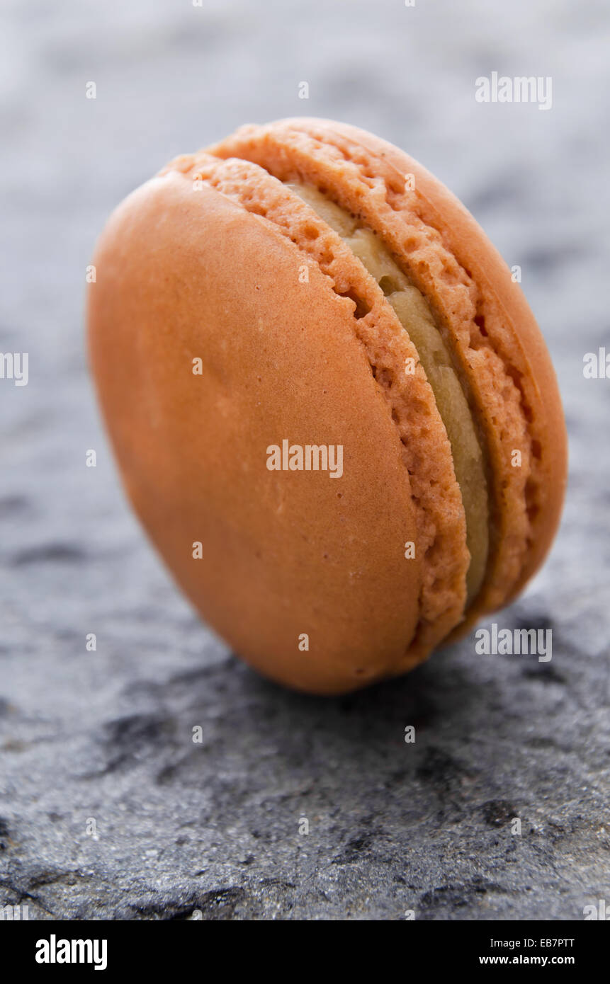 Single sweet macaroon biscuit over gray stone Stock Photo - Alamy