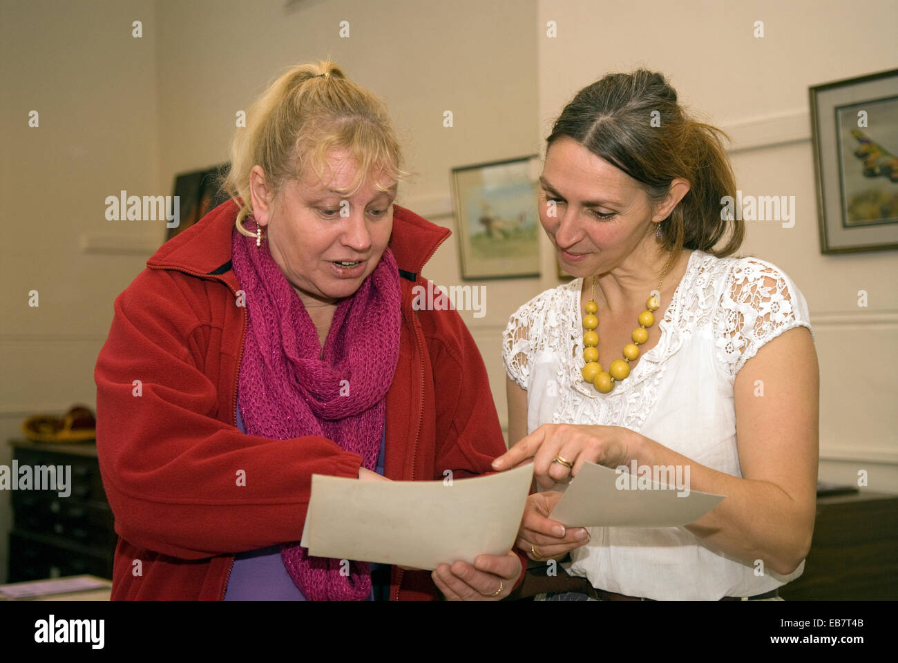 Two women perusing old photos at a heritage open day at local arts ...